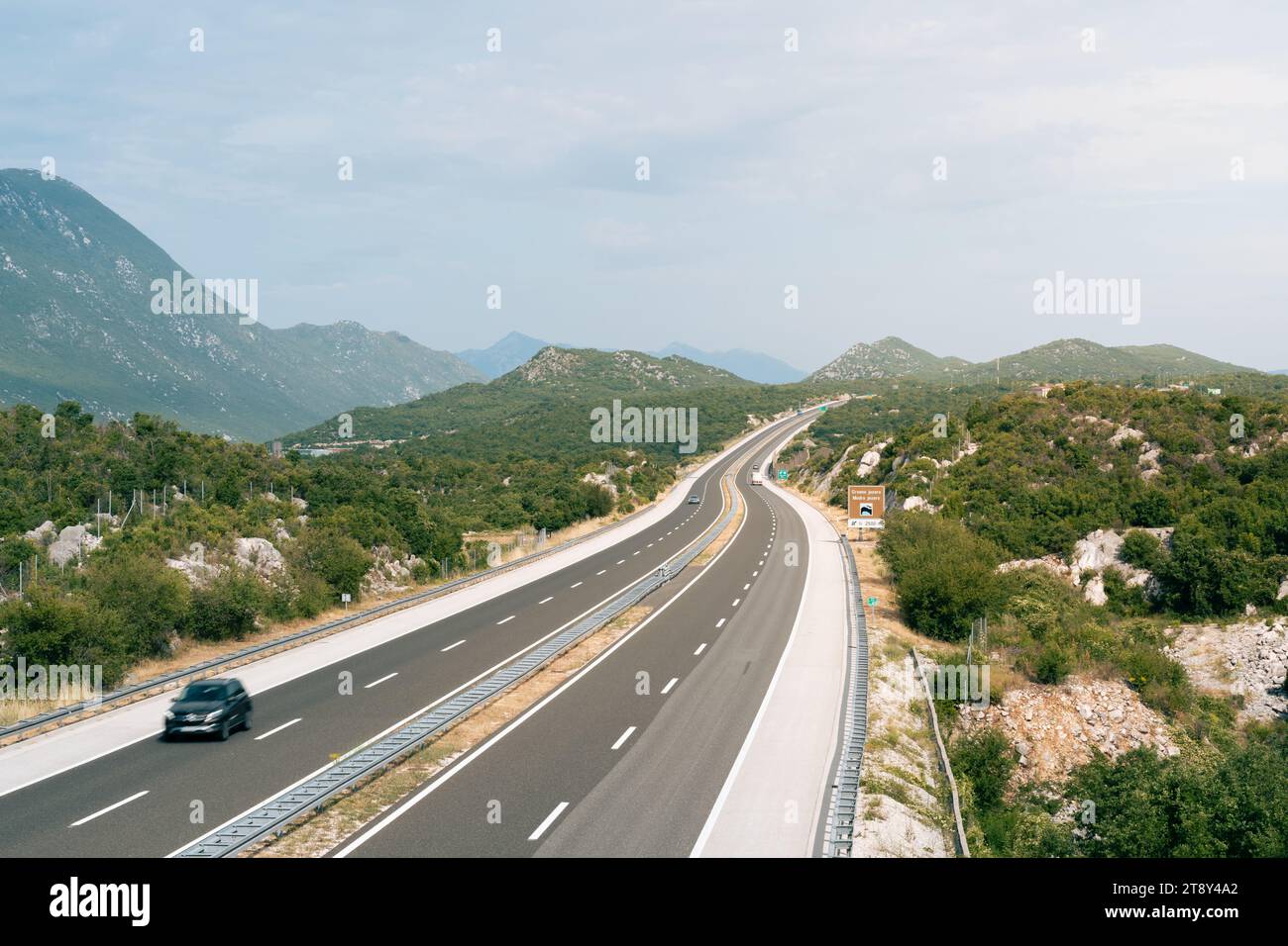 A long, winding highway stretching through a mountainous landscape. The ...