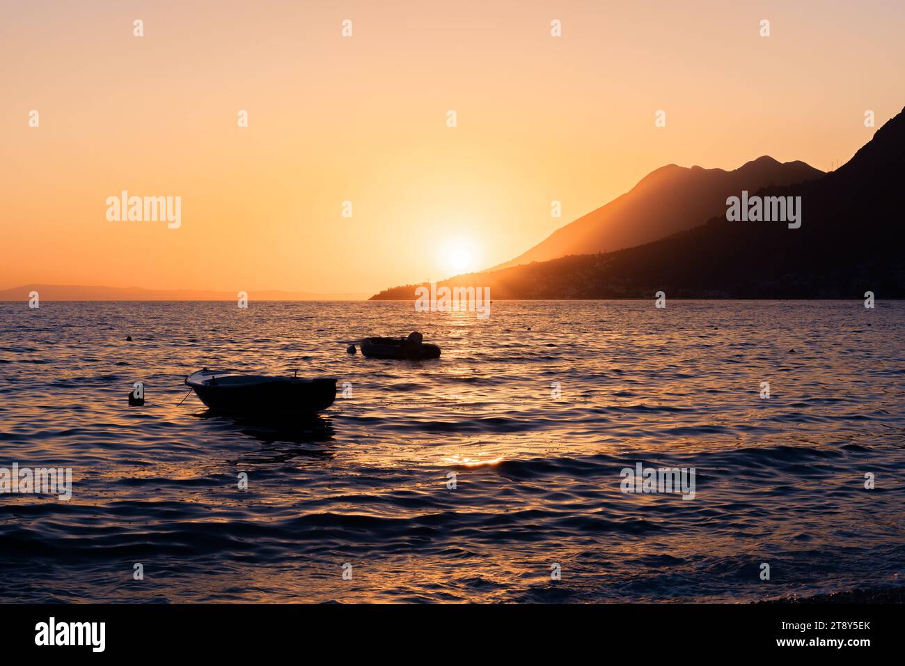 Sea in the sunset, two small boats on water Stock Photo - Alamy