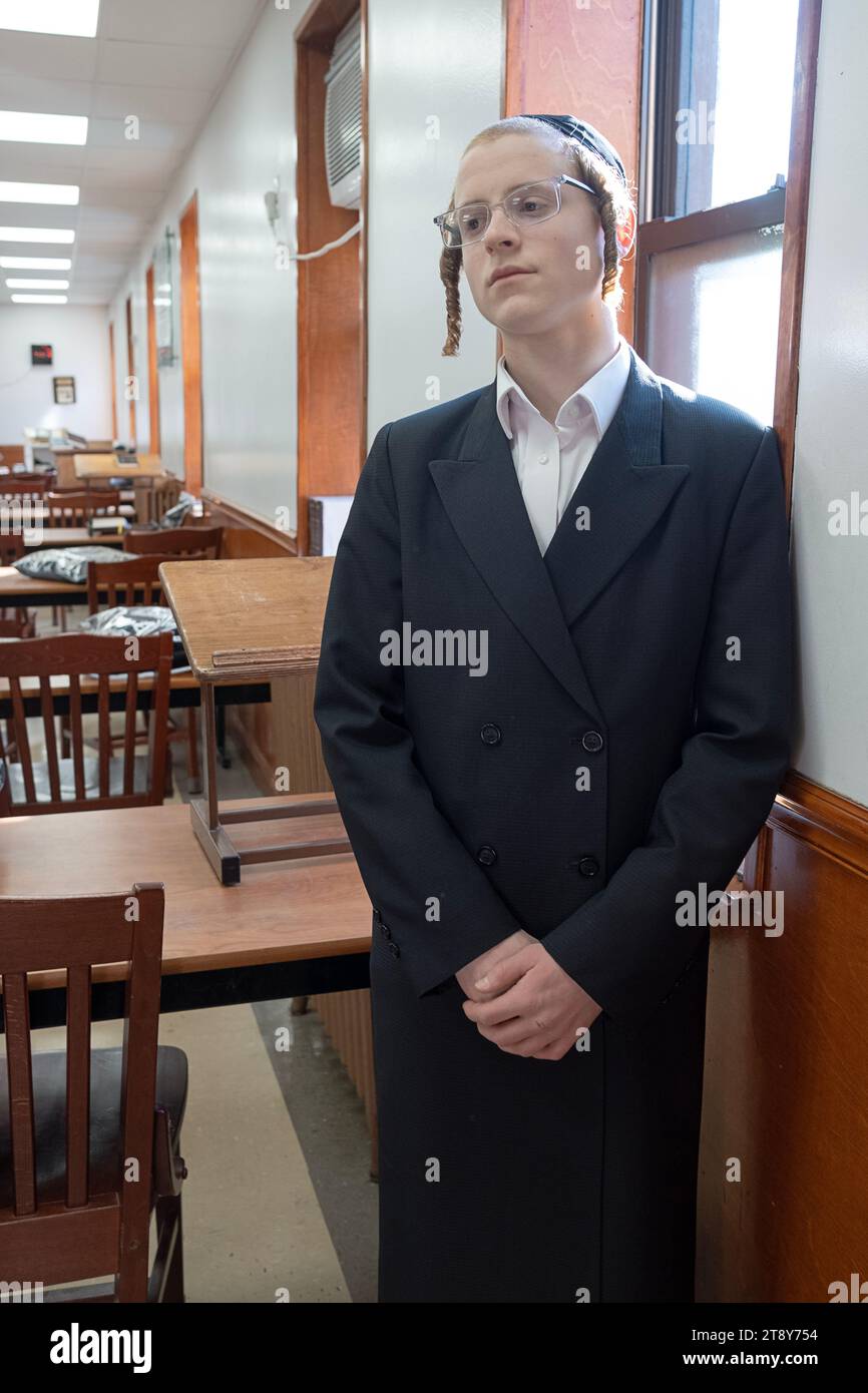 Posed photo of a thoughtful pensive young man in a small synagogue ...