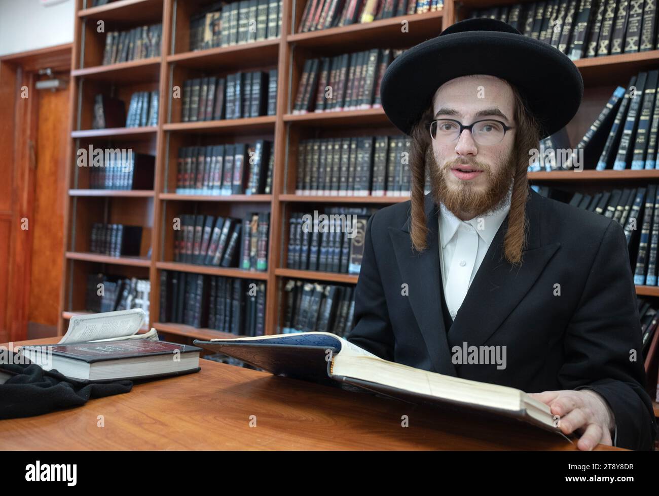 An orthodox Jewish man with long peyus pauses from his studies. In a ...