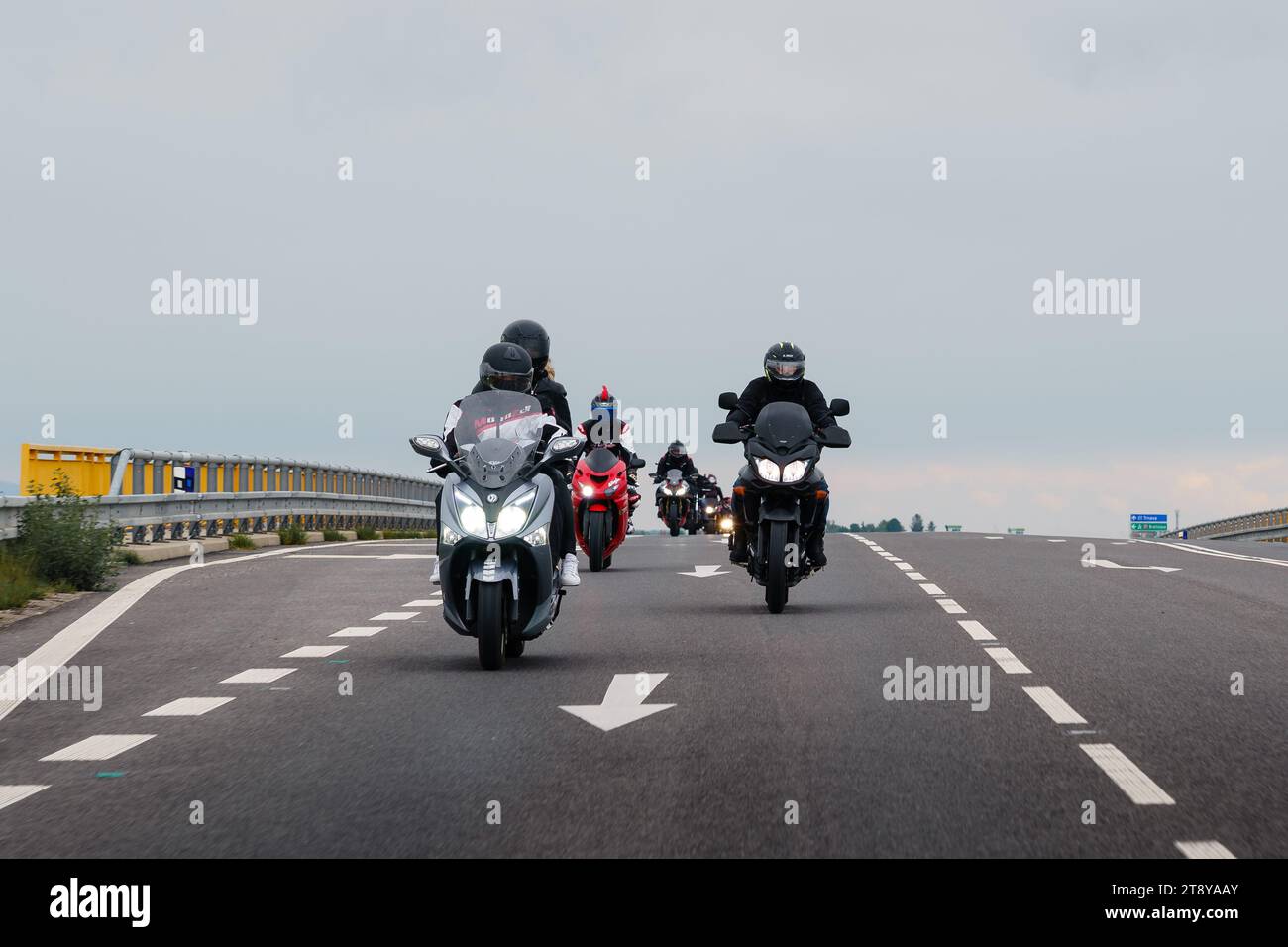 group of motorcycle riders riding together on the public road Stock ...