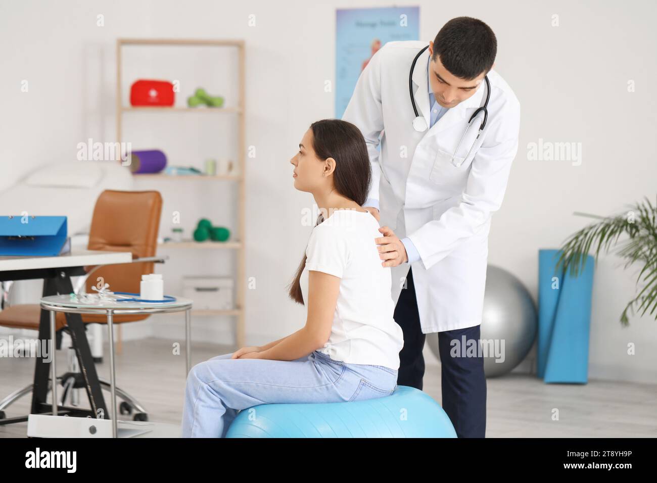 Male doctor checking posture of young woman in clinic Stock Photo - Alamy