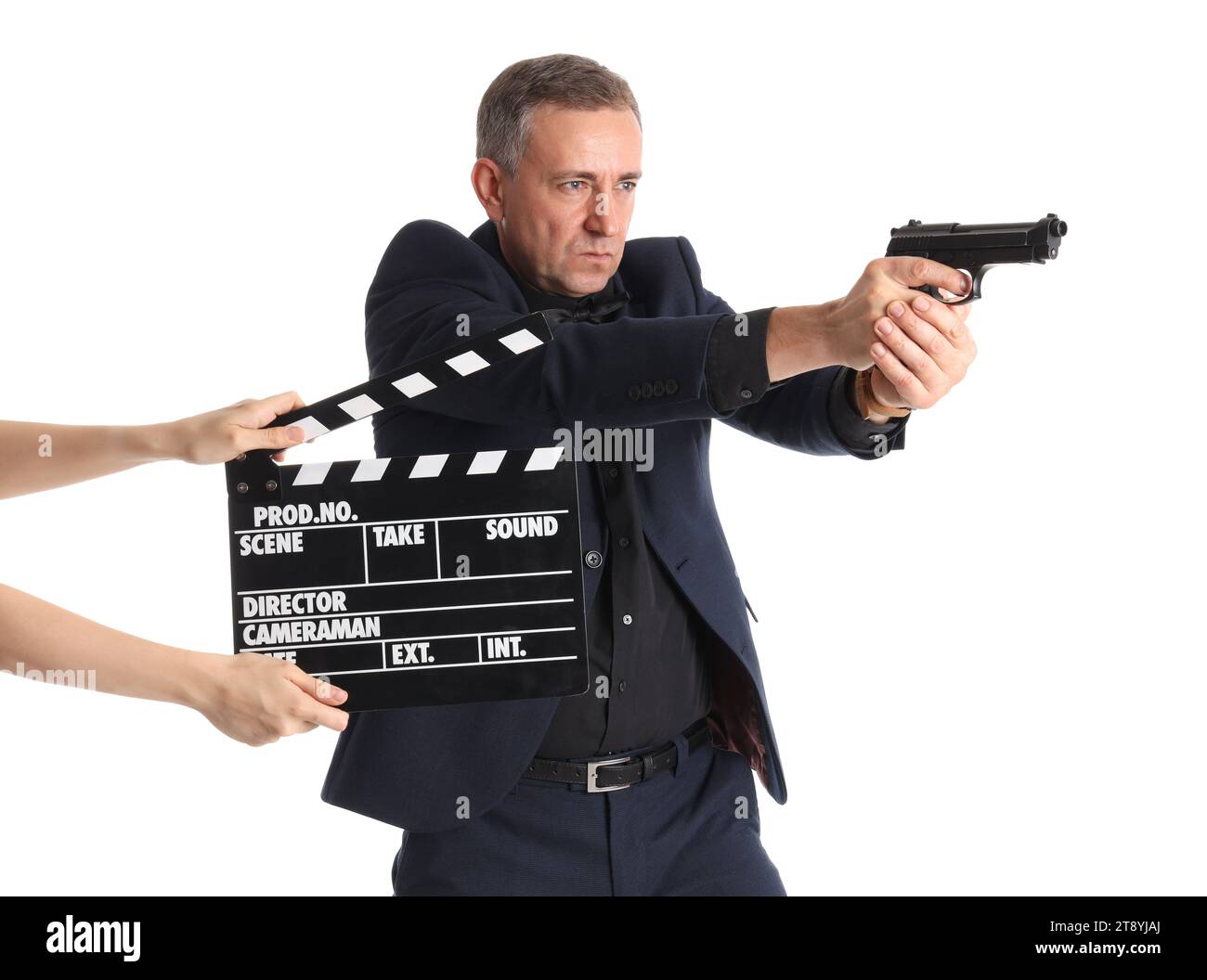 Mature actor holding gun and hands with clapperboard on white ...