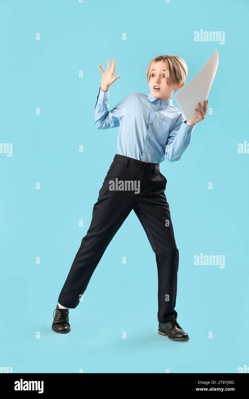 Scared little actor with film script on blue background Stock Photo - Alamy