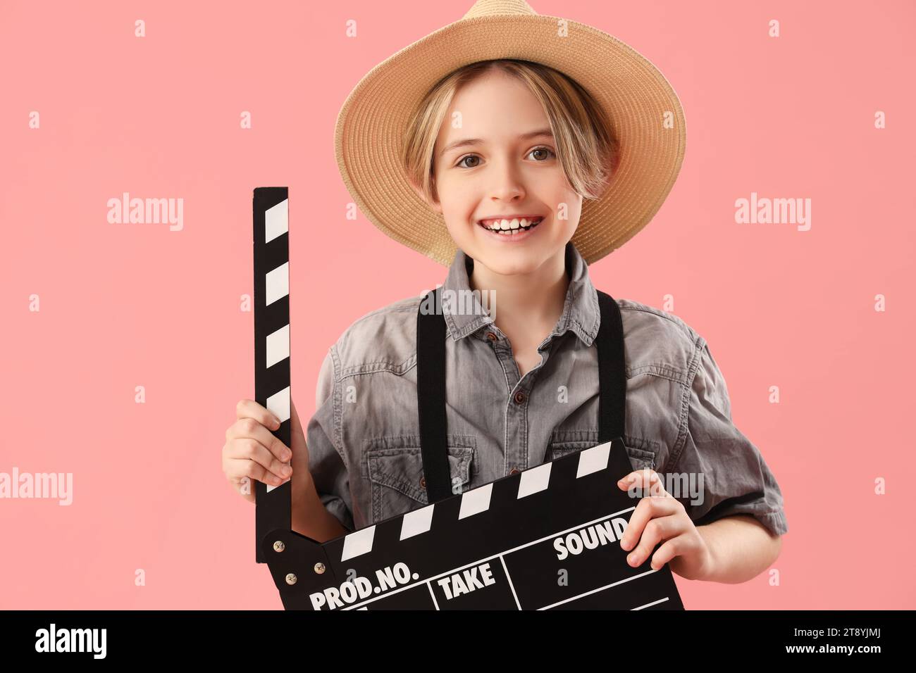 Little actor with movie clapper on pink background Stock Photo - Alamy