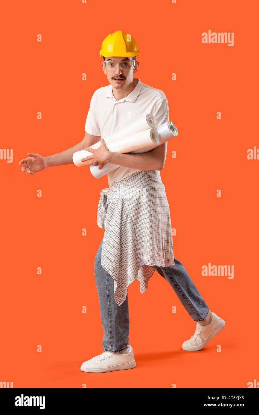 Male worker with wallpapers on orange background Stock Photo - Alamy