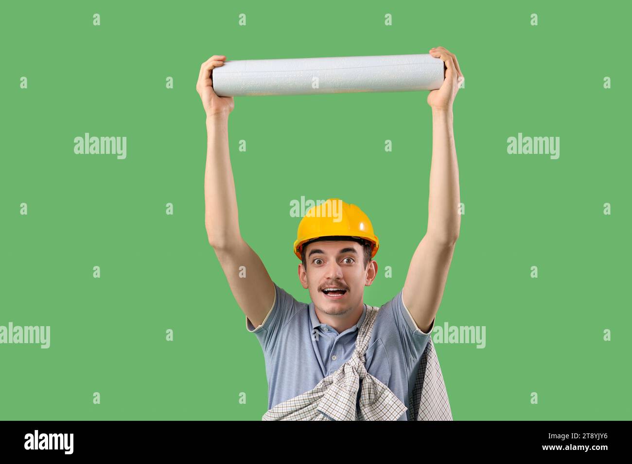 Male worker with wallpaper on green background Stock Photo - Alamy