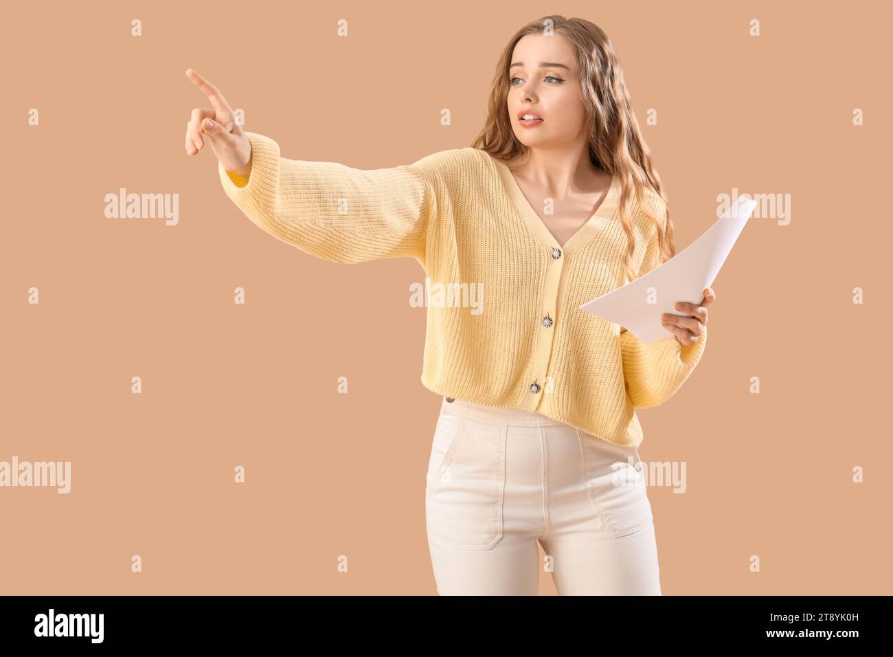 Beautiful actress with film script on beige background Stock Photo - Alamy