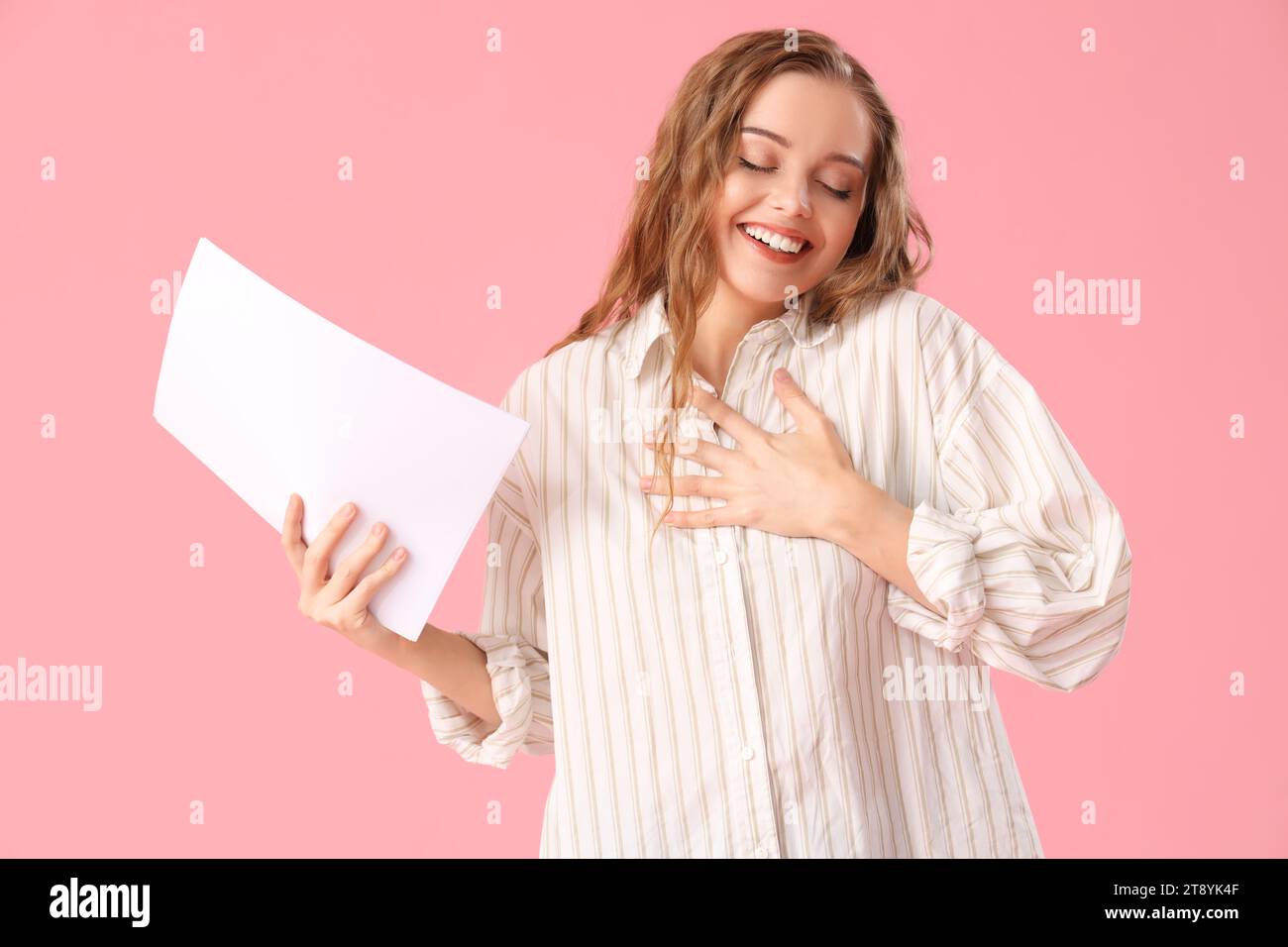 Beautiful actress with film script on pink background Stock Photo - Alamy