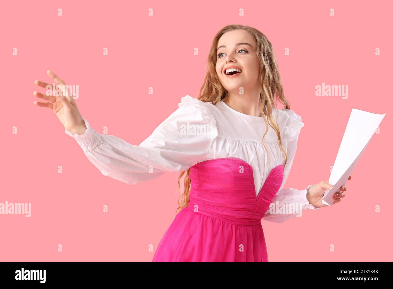 Beautiful actress with film script on pink background Stock Photo - Alamy