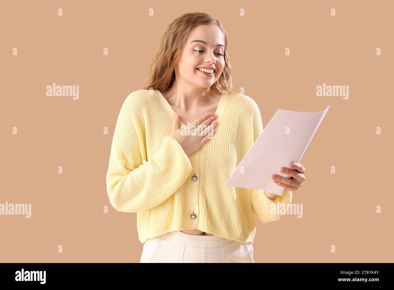 Beautiful actress with film script on beige background Stock Photo - Alamy