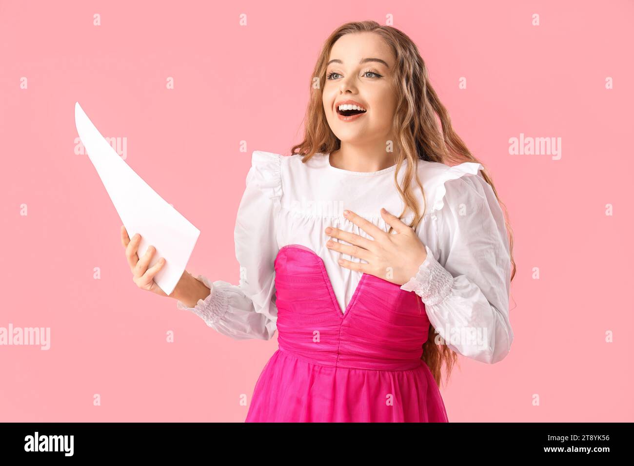 Beautiful actress with film script on pink background Stock Photo - Alamy