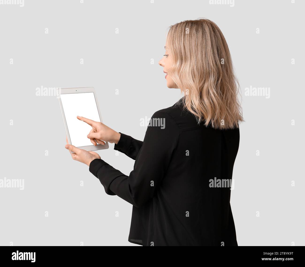 Pretty young woman using modern tablet computer with blank screen on ...