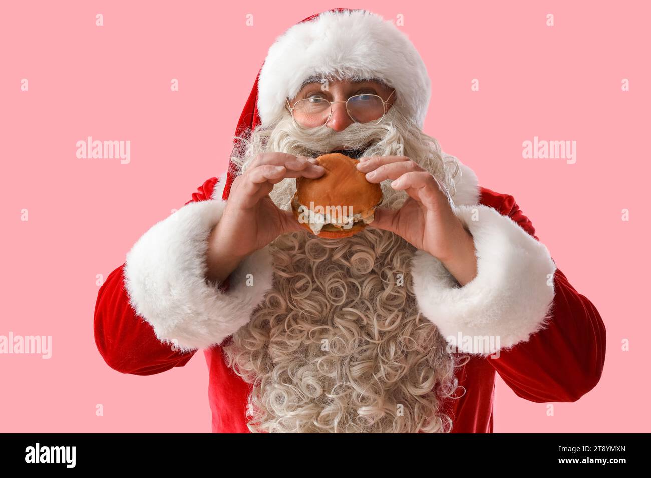 Santa Claus eating tasty burger on pink background Stock Photo - Alamy