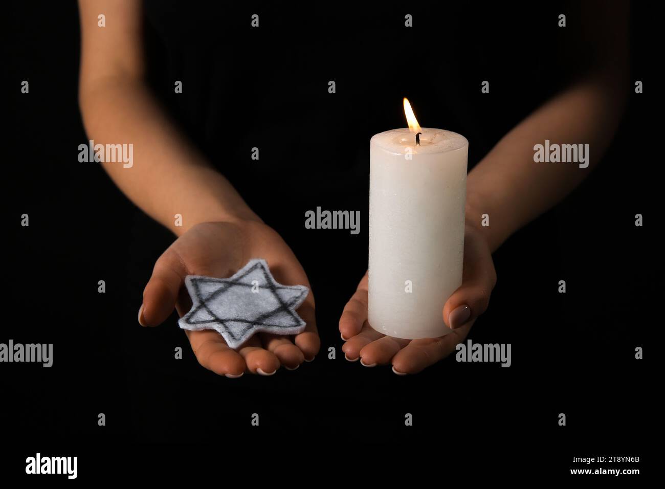 Woman with burning candle and Jewish badge on dark background, closeup ...