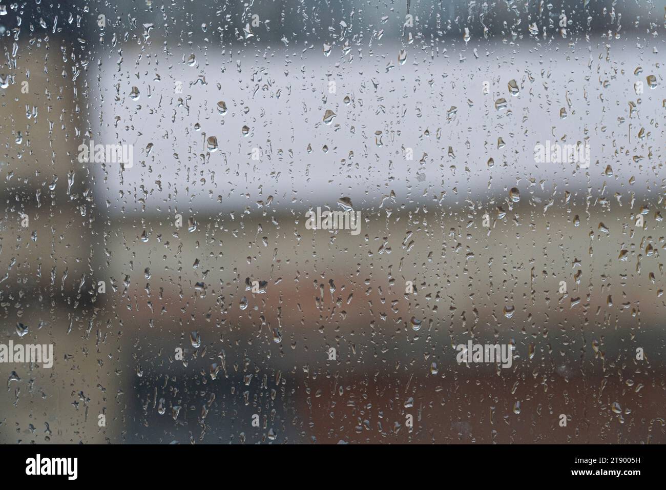 Raindrops on the window glass. Blurred colored background outside the ...