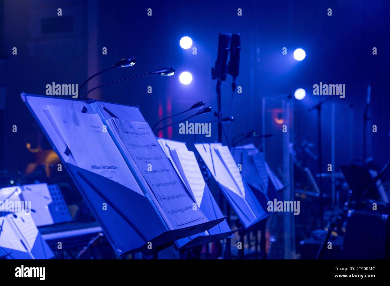 music stands with orchestral notes. Dim stage of the concert hall ...