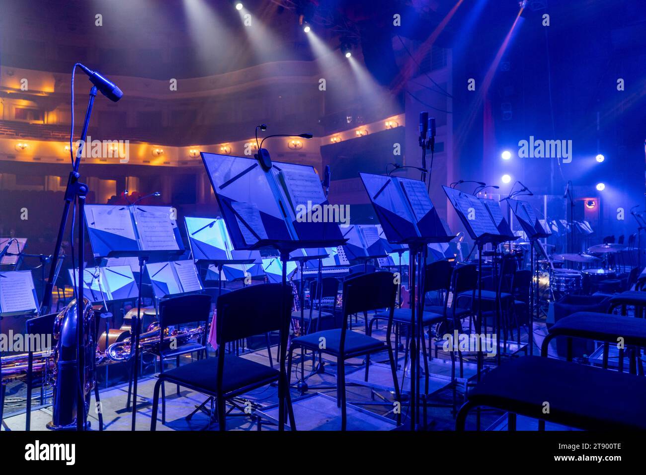 music stands with orchestral notes. Dim stage of the concert hall ...