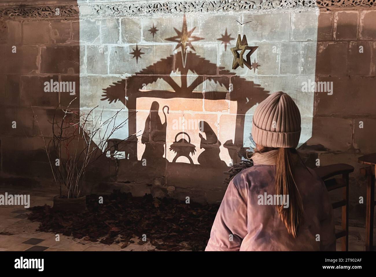 A child looks at christmas creche with Joseph Mary and small Jesus ...