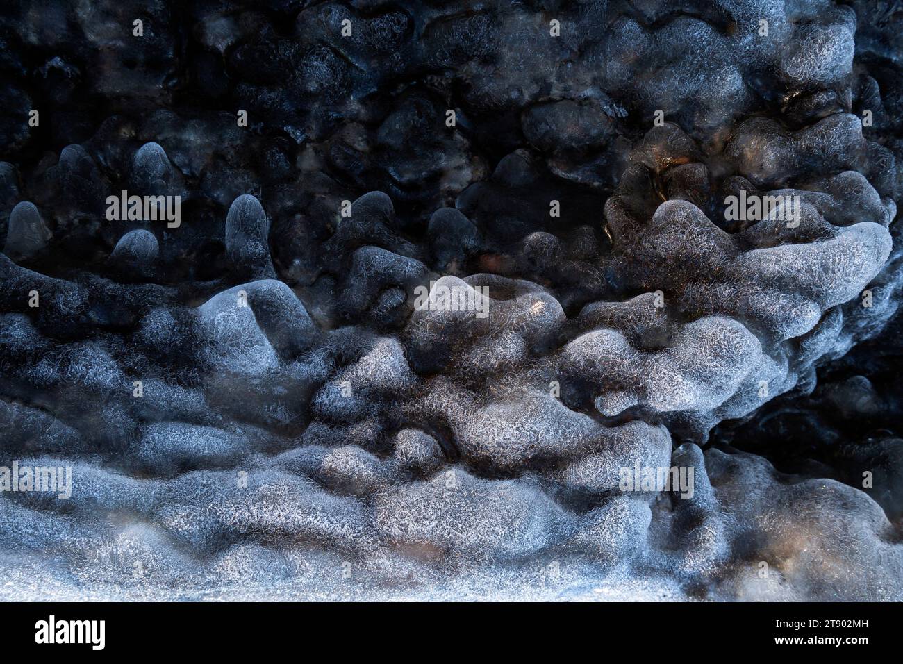 Macro close-up of frozen and frosty ice formations with smooth curves ...