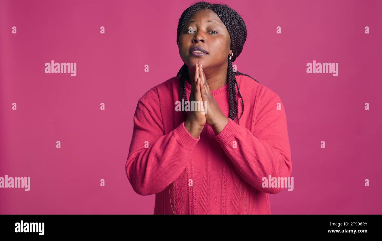 Young african american female earnestly begging with her hands together ...