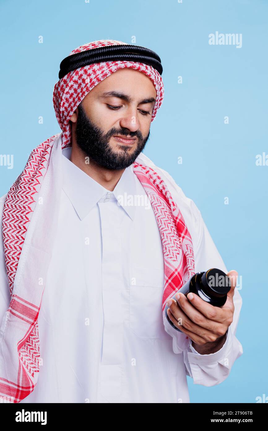 Man wearing traditional muslim attire checking instruction on ...