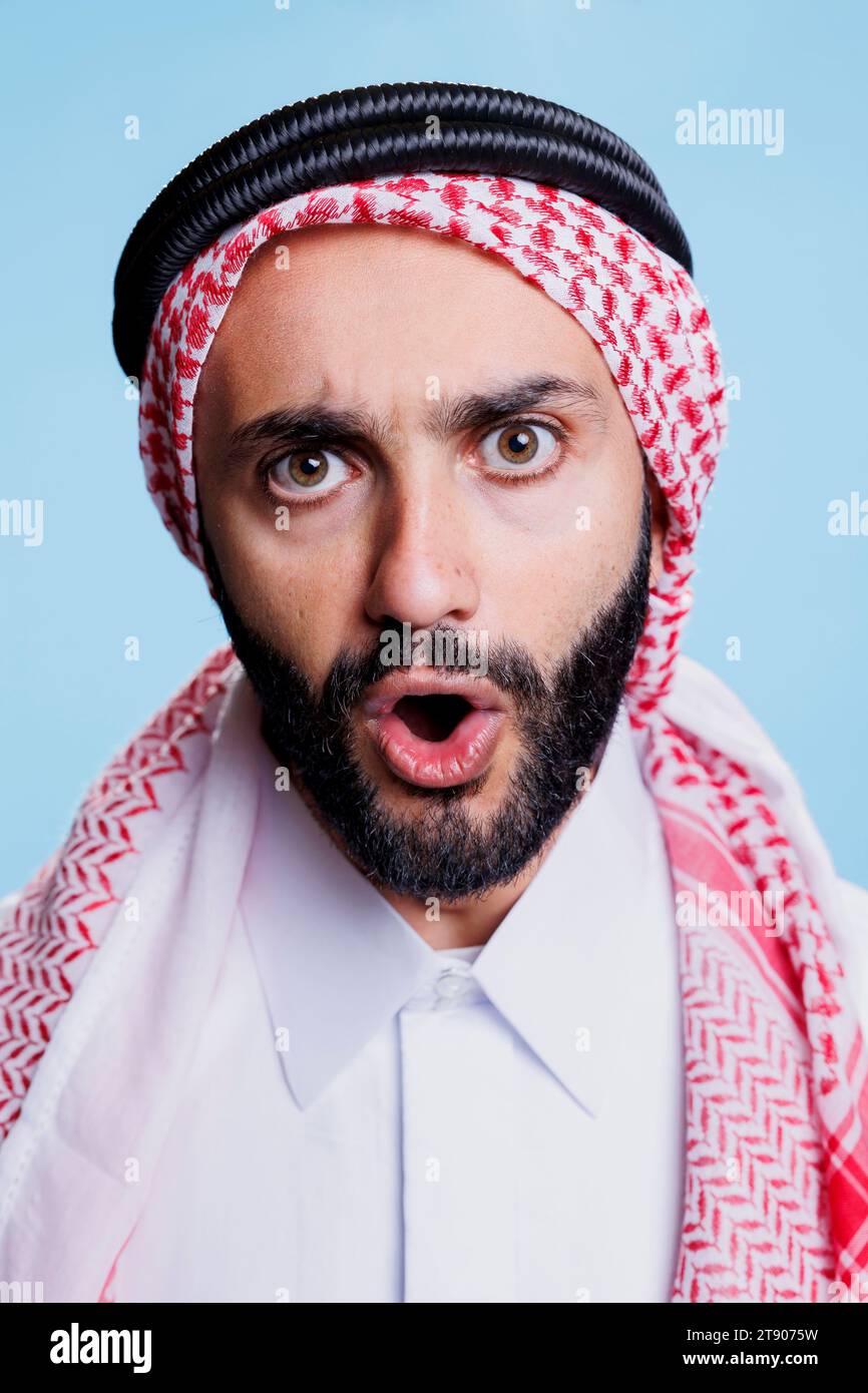 Muslim man with open mouth wearing traditional checkered ghutra ...