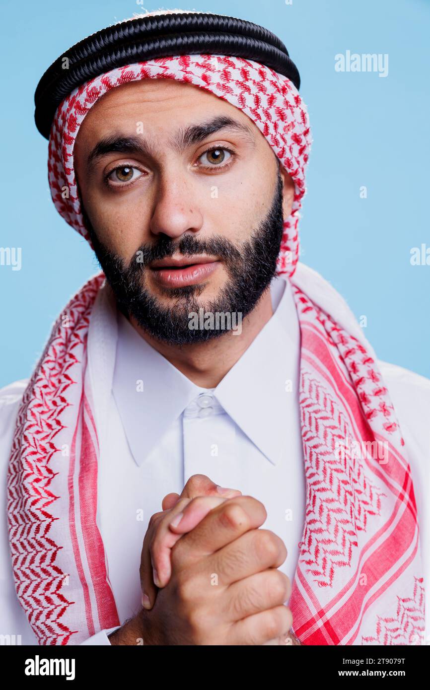 Muslim prayer wearing traditional arab clothes showing religious belief ...