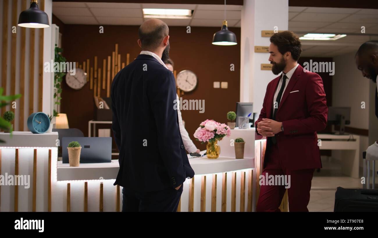 Staff team welcoming businessmen in lobby, greeting guests before ...