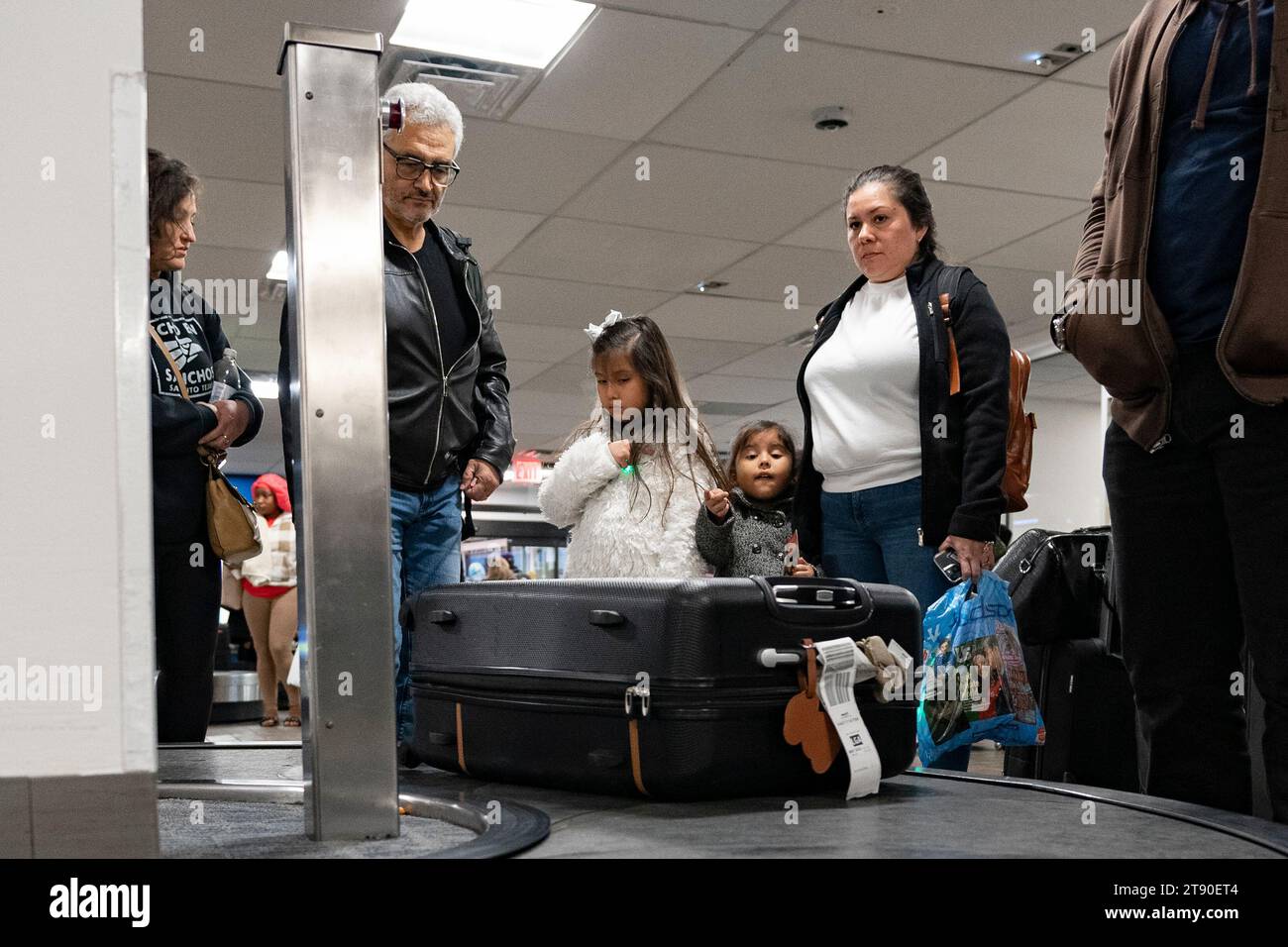 Airline passengers wait to retrieve their suitcases from a baggage claim carousel at LaGuardia ...