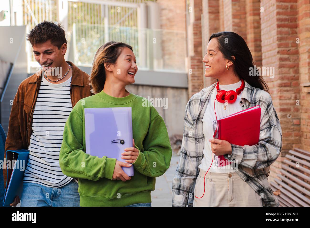 Group of highschool classmates going to class carrying their folders ...