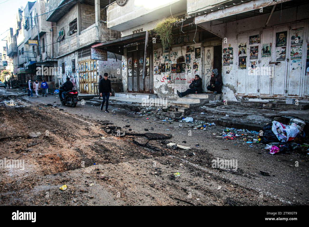 Nablus, Palestine. 21st Nov, 2023. Palestinians walk past a damaged ...