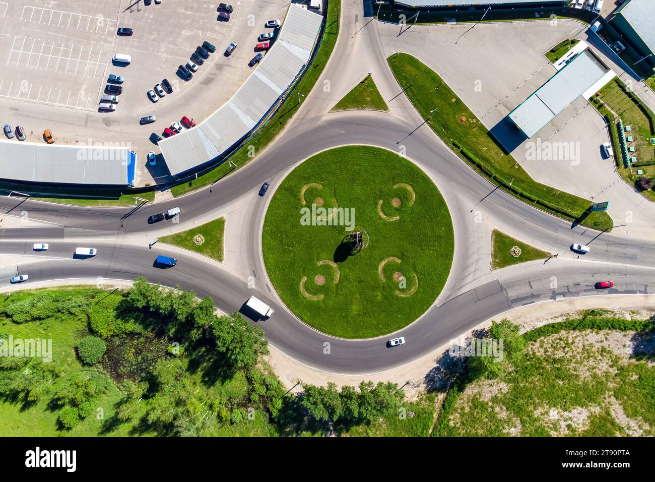 Aerial view of a roundabout with a large green flowerbed and cars ...