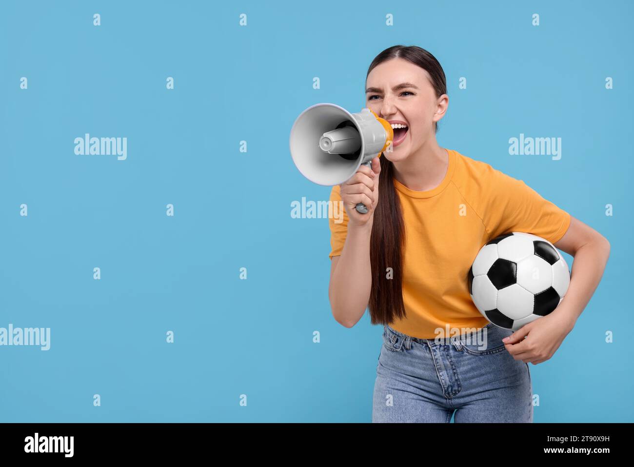 Soccer fan with ball shouting in megaphone on light blue background ...