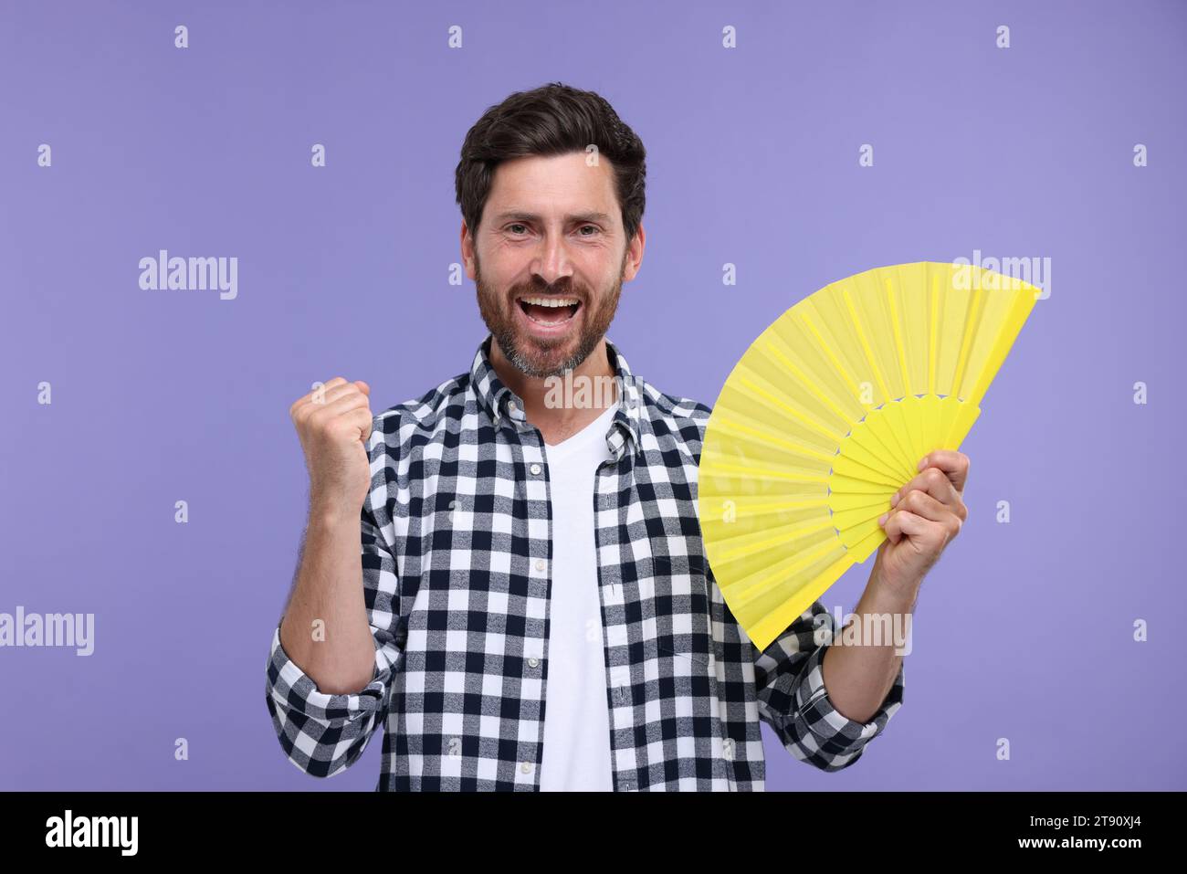 Happy man holding hand fan on purple background Stock Photo - Alamy