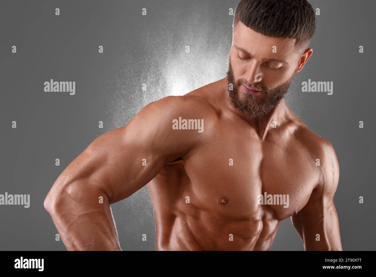 Young bodybuilder with muscular body on grey background Stock Photo - Alamy