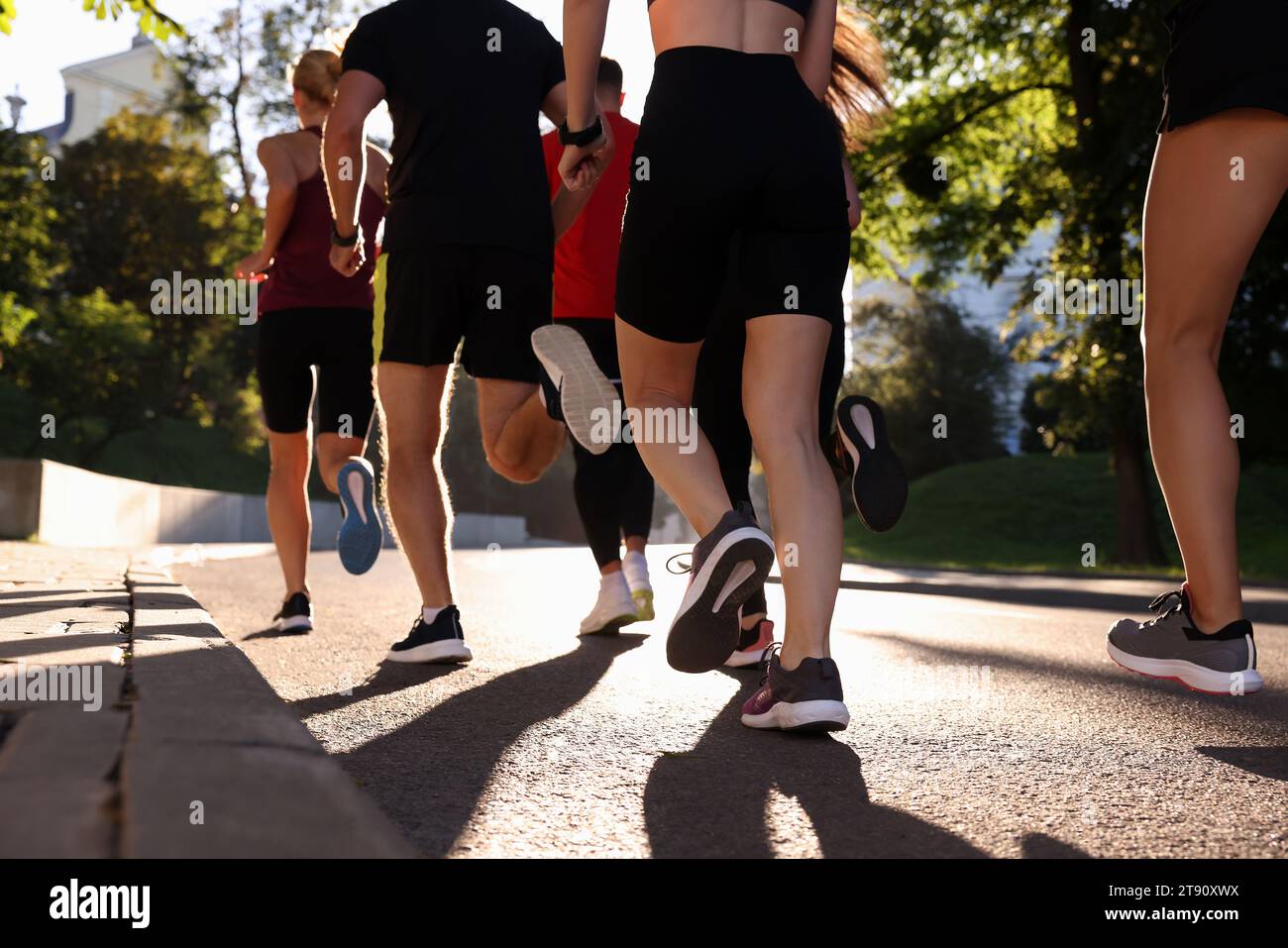Group of people running outdoors on sunny day, back view Stock Photo ...