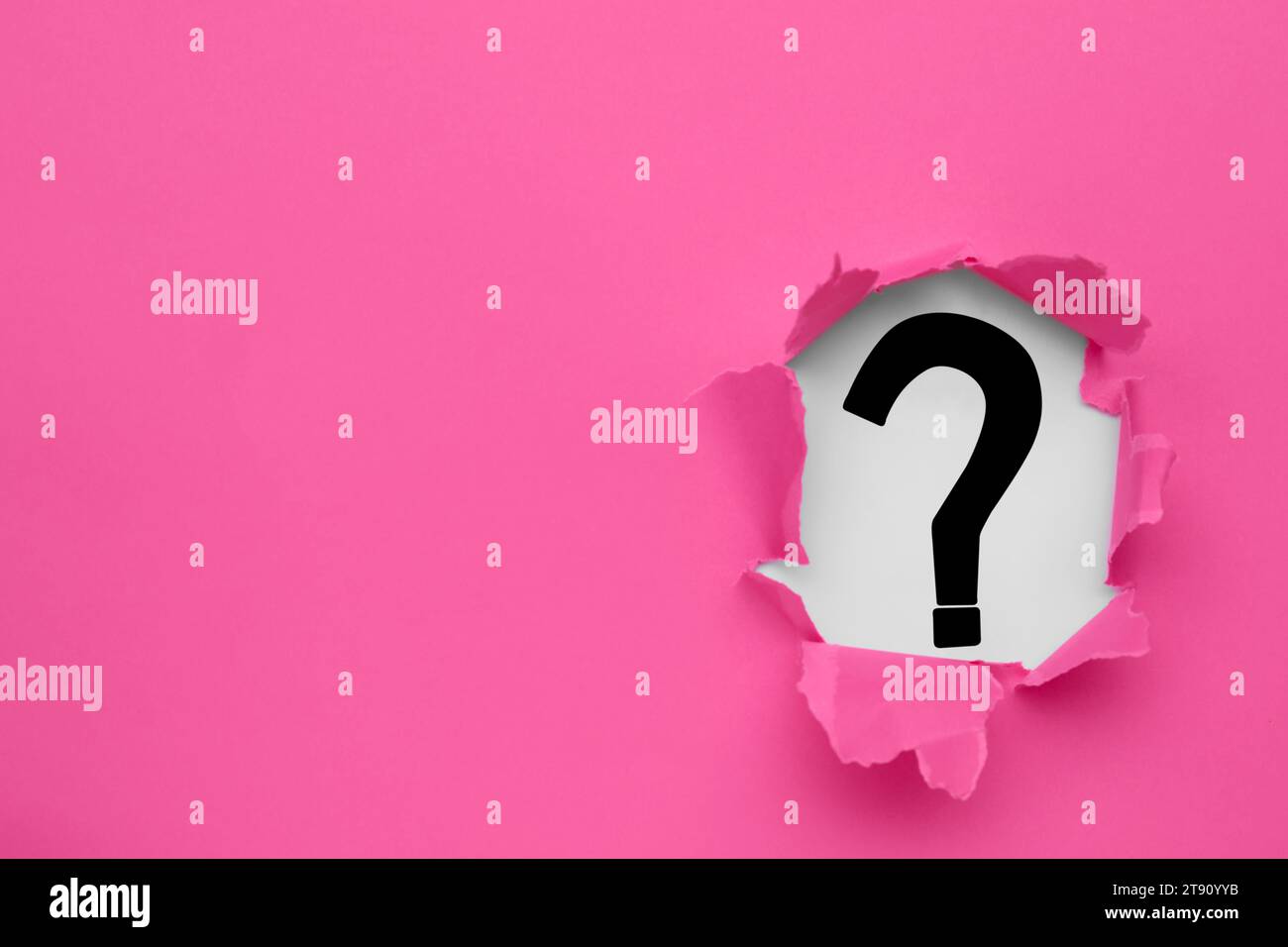 Question mark on white background, view through hole in pink paper ...