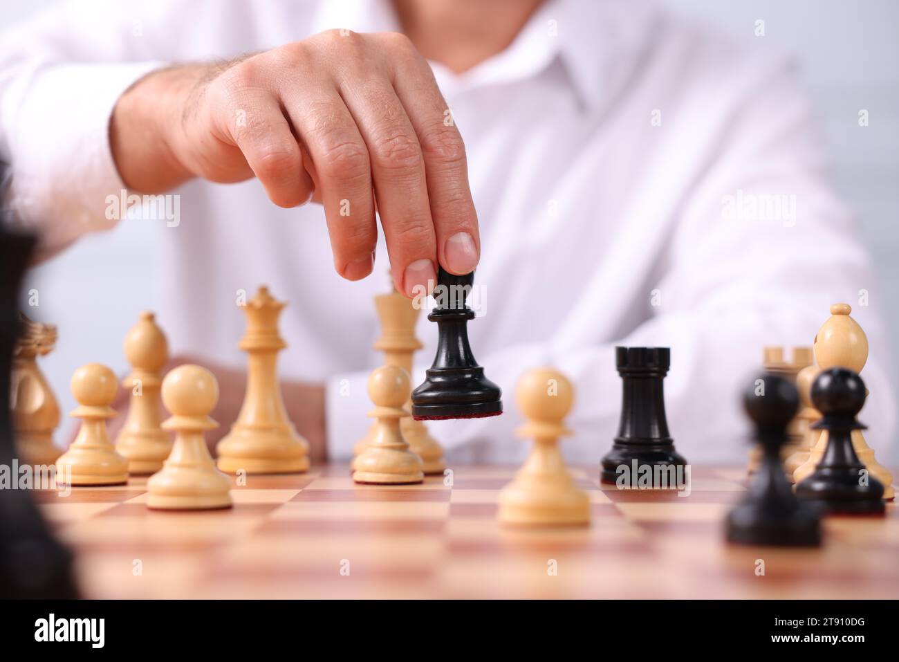 Man moving chess piece at checkerboard, closeup Stock Photo - Alamy