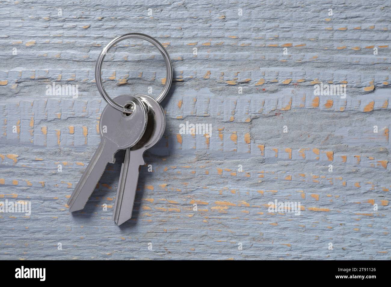 Keys with ring on grey wooden table, top view. Space for text Stock ...