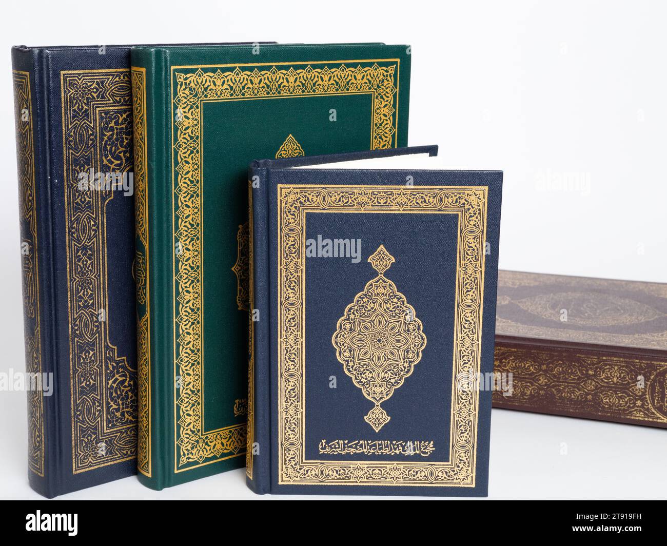 a set of holy quran books of various sizes isolated on a white ...