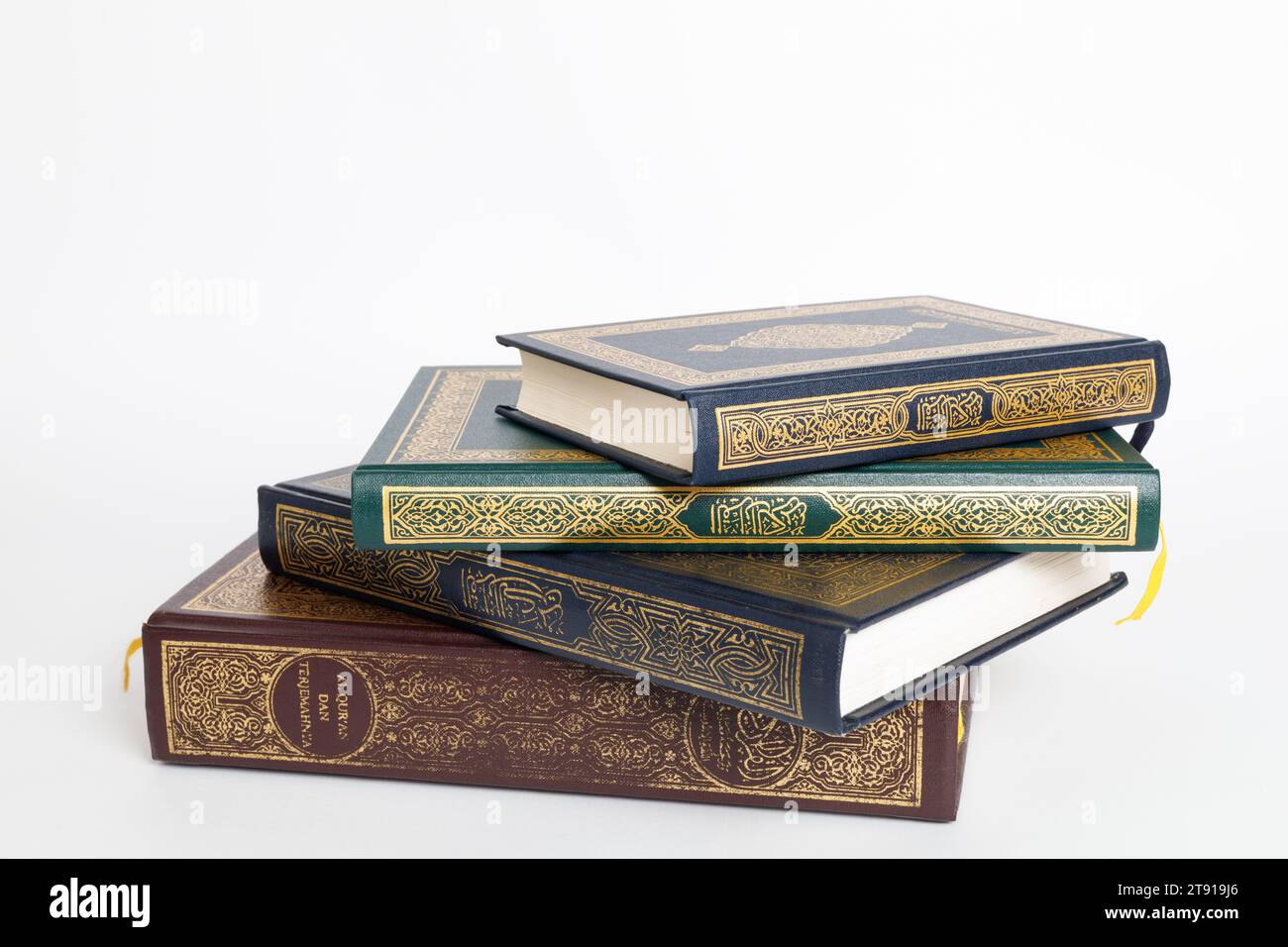 a set of holy quran books of various sizes isolated on a white ...