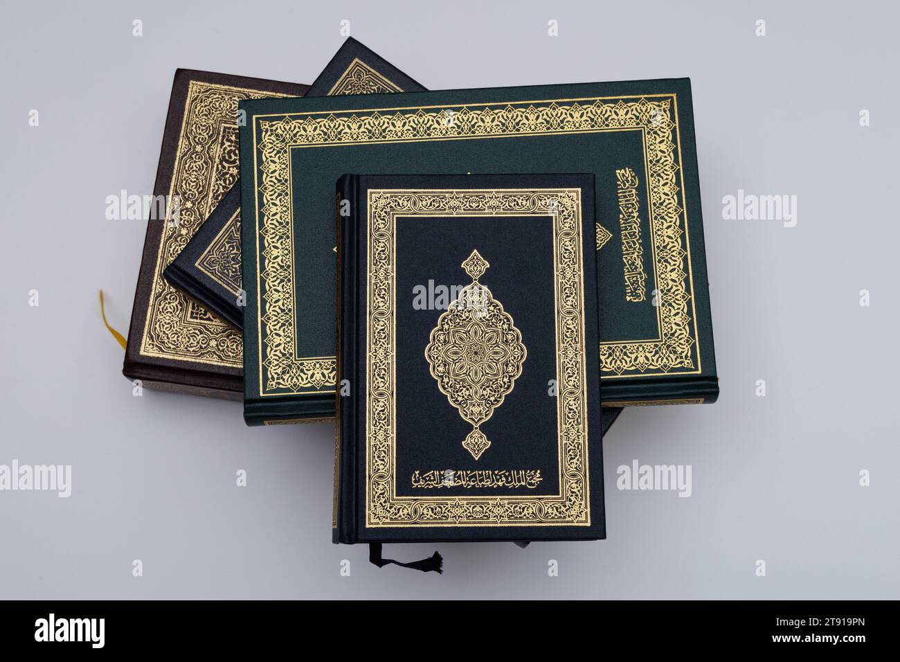 a set of holy quran books of various sizes isolated on a white ...