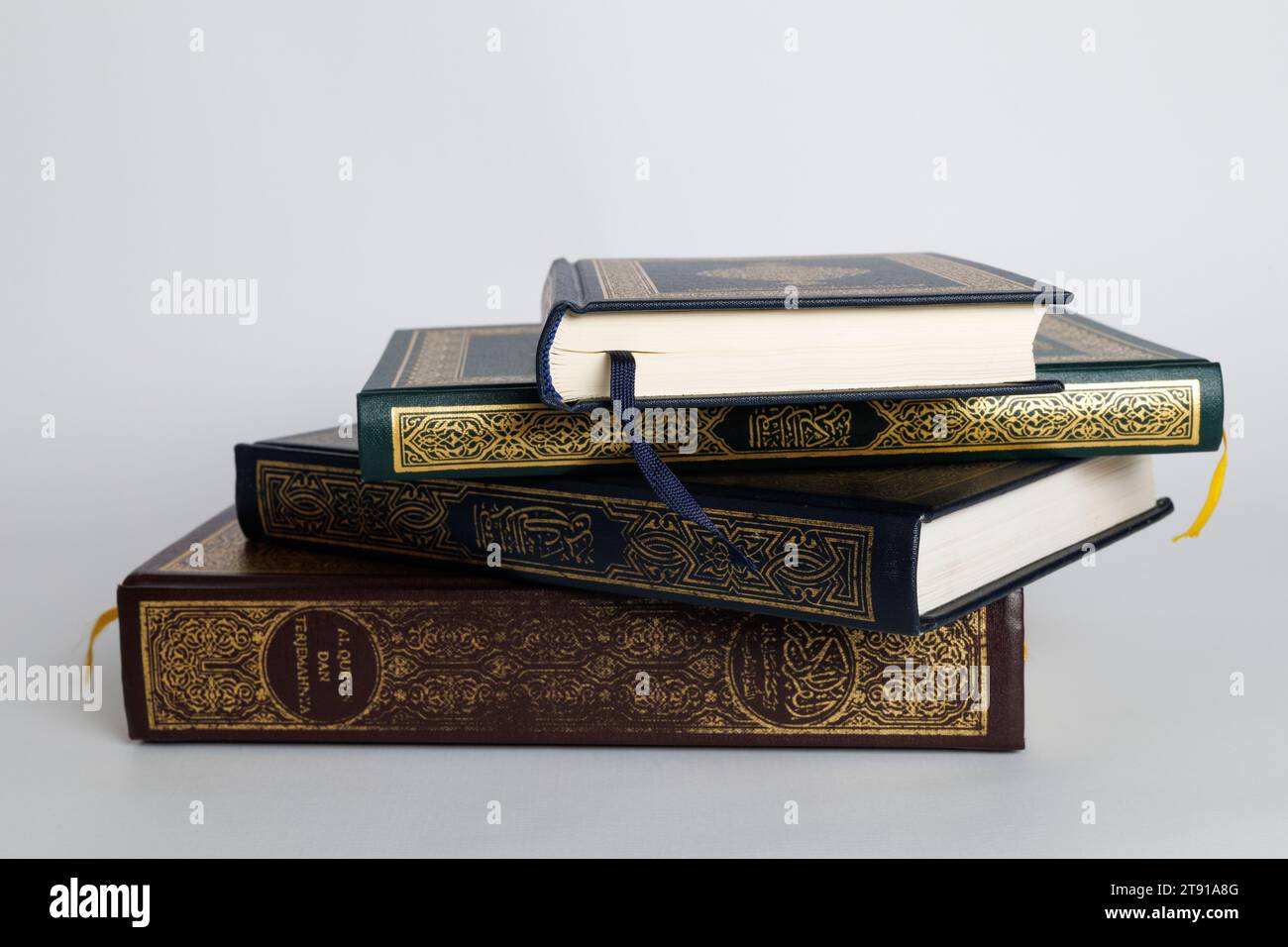 a set of holy quran books of various sizes isolated on a white ...