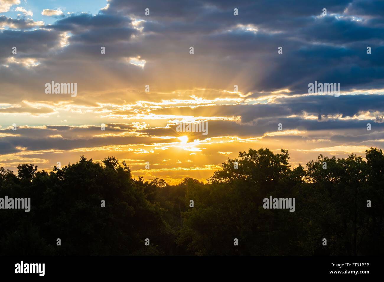 Sunrise in clouds with sun rays Stock Photo - Alamy