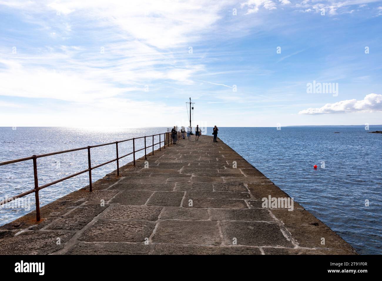 Visitors walk on Portleven Pier, blue sky autumn day,Cornwall,England ...