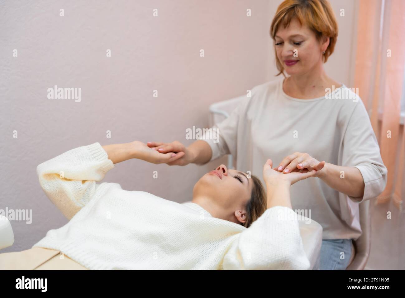 Healer woman launches body energy through hands before access bars ...