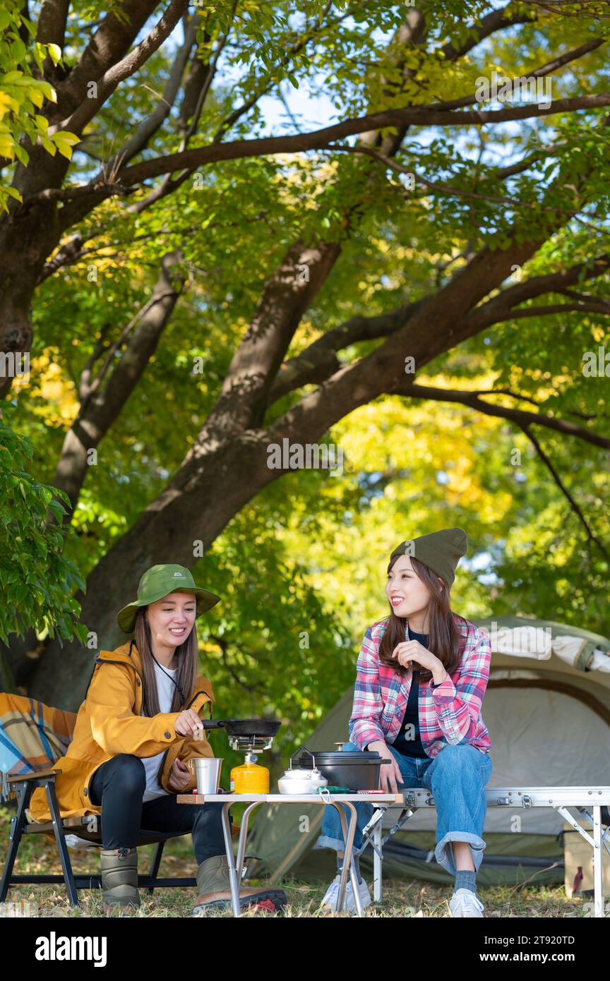 Two women enjoying camping Stock Photo - Alamy