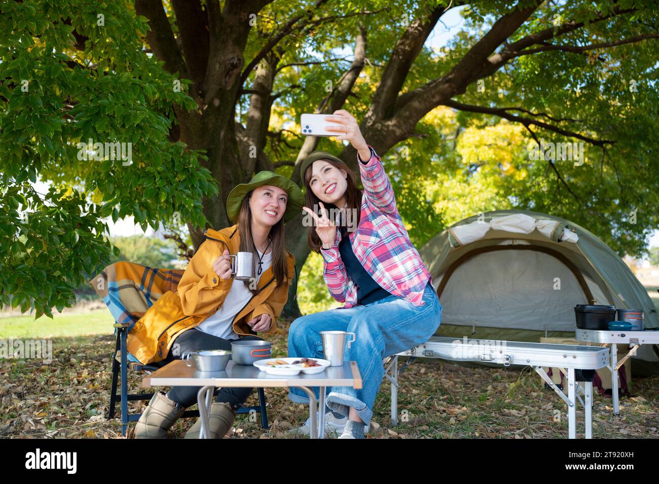 Two women enjoying camping Stock Photo - Alamy