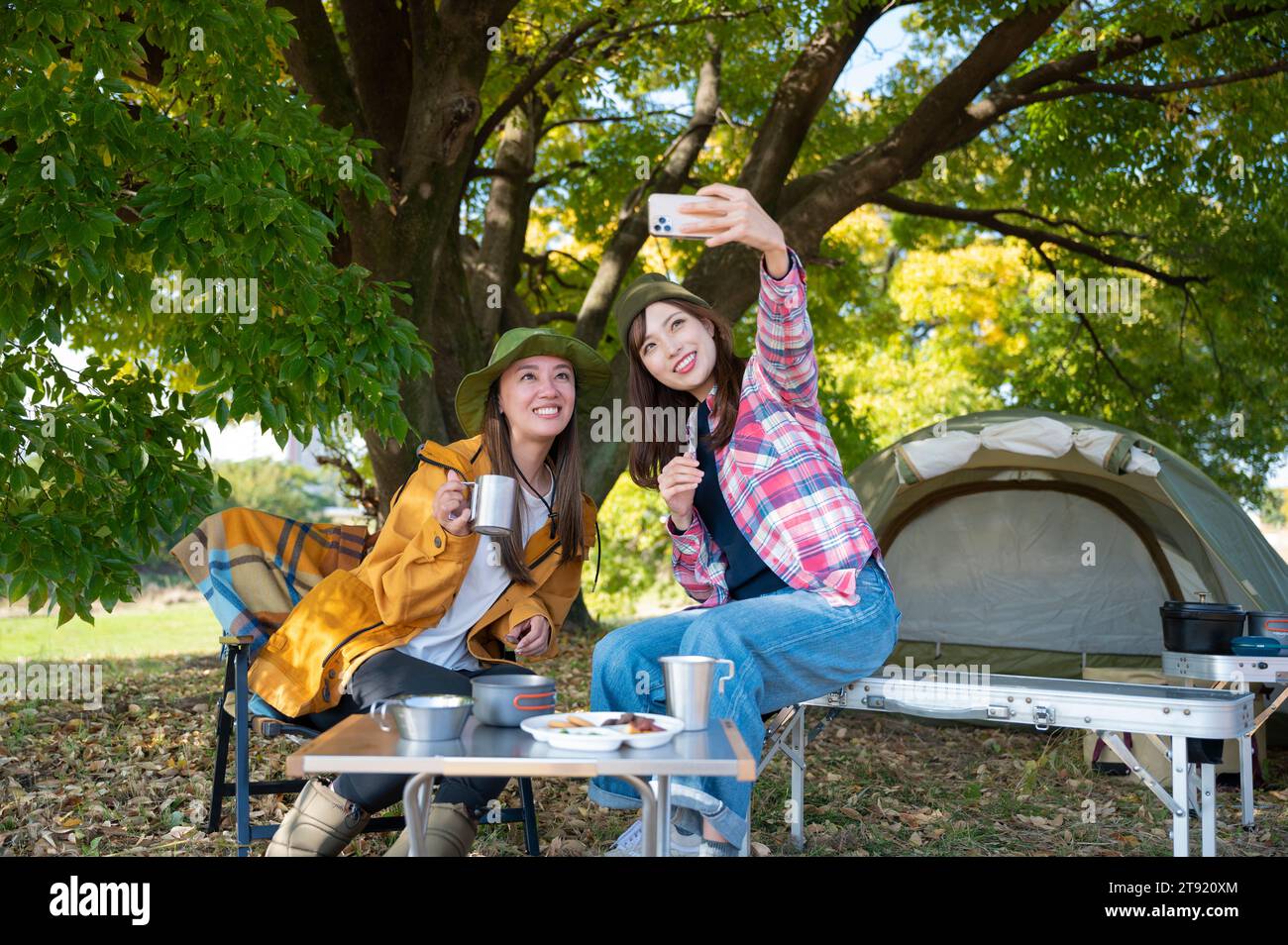 Two women enjoying camping Stock Photo - Alamy